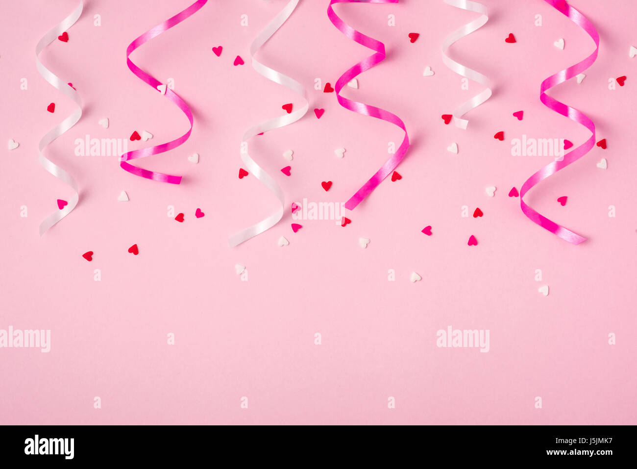 Delicate pink party background with streamers for celebrating with ...