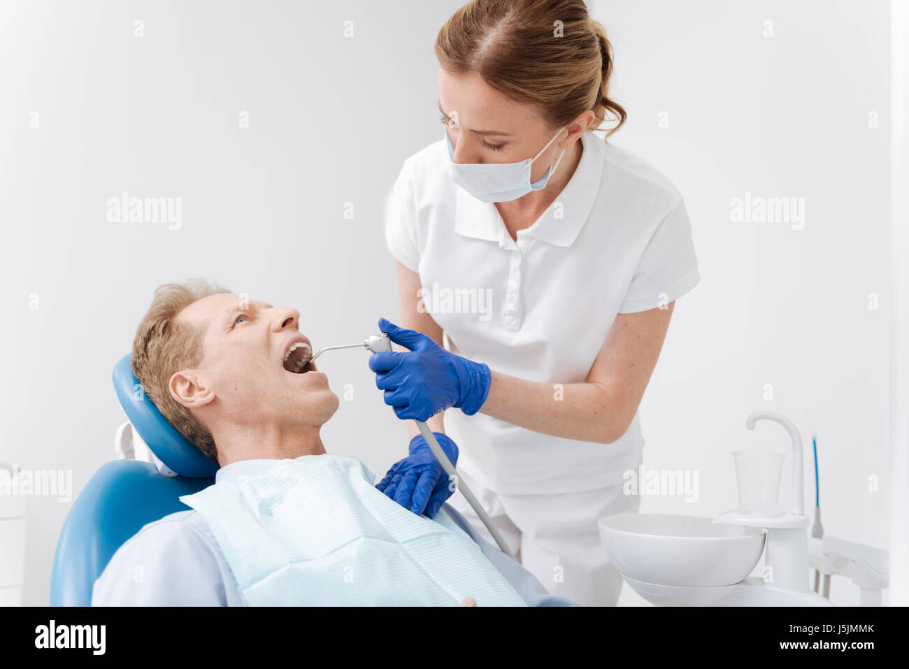 Capable skillful expert having dental treatment done Stock Photo - Alamy