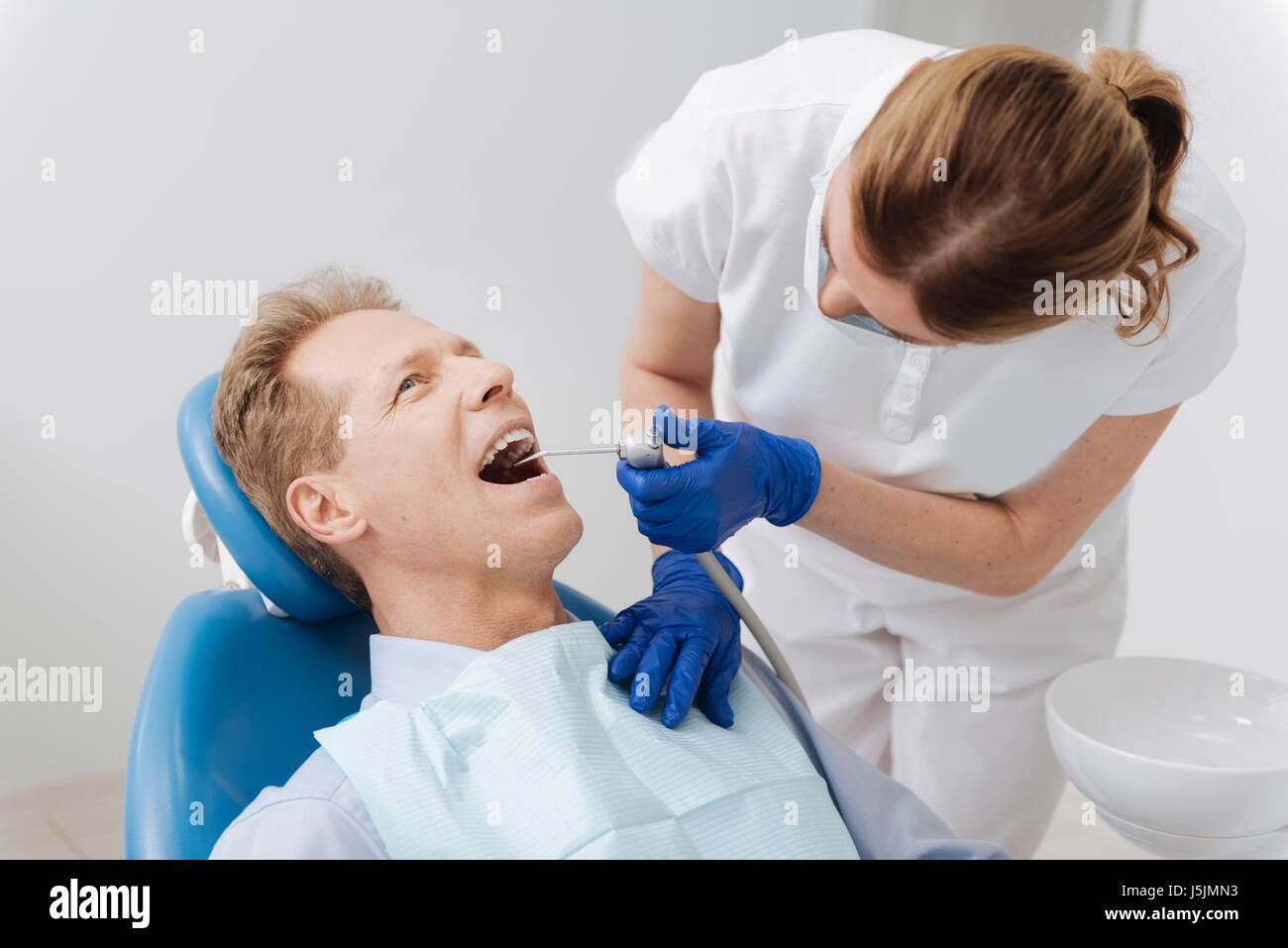 Delicate neat dentist performing dental manipulation Stock Photo - Alamy