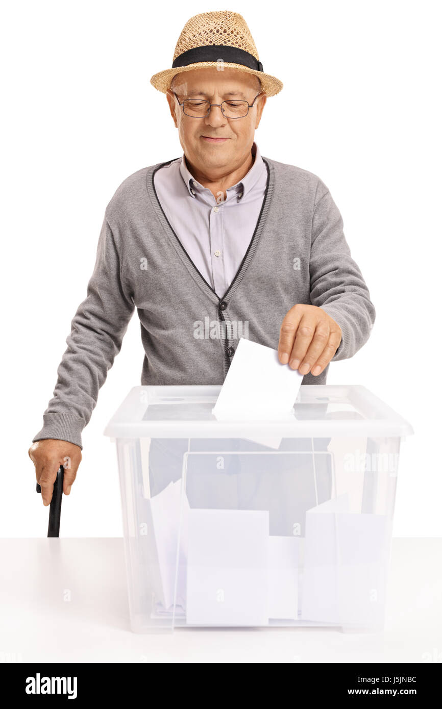 Elderly voter putting a ballot into a voting box isolated on white ...