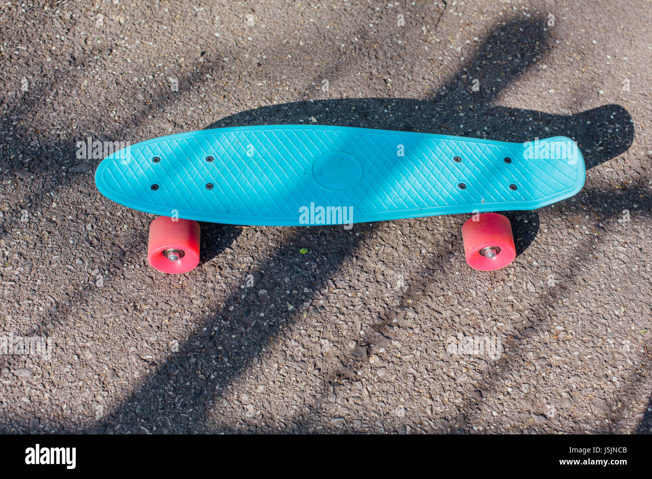 Blue penny board with pink wheels stands on the track Stock Photo - Alamy