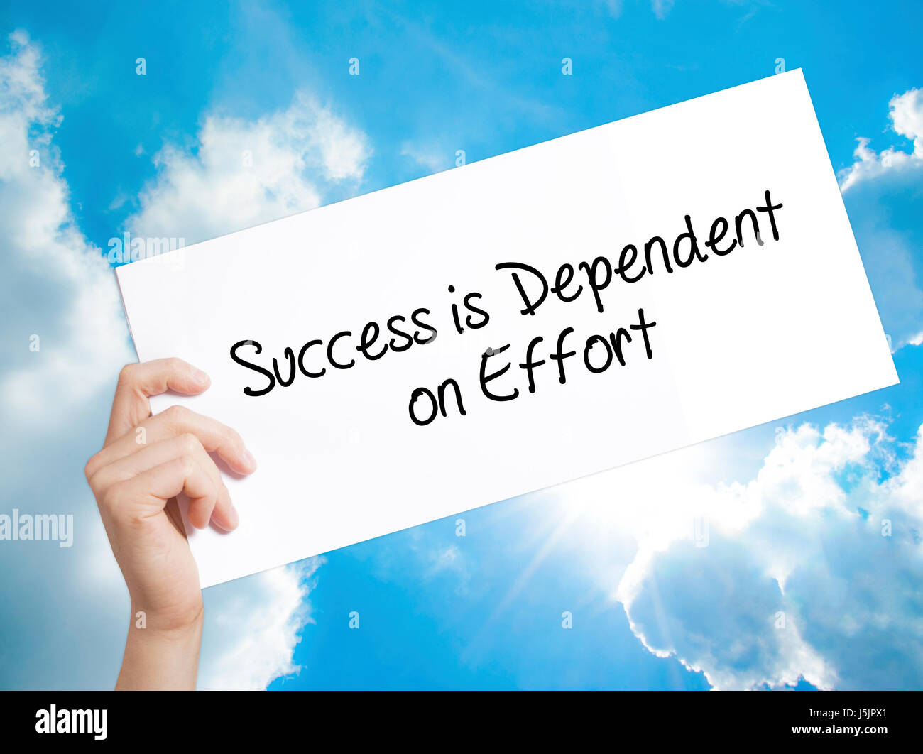 Success is Dependent on Effort Sign on white paper. Man Hand Holding ...