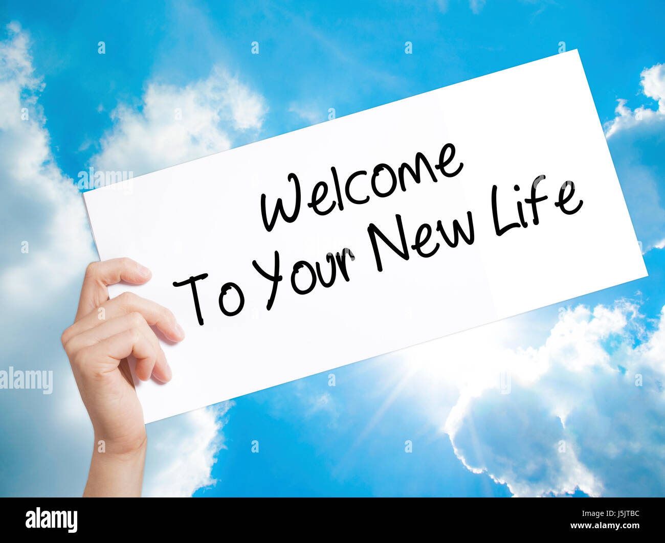 Welcome To Your New Life Sign on white paper. Man Hand Holding Paper ...