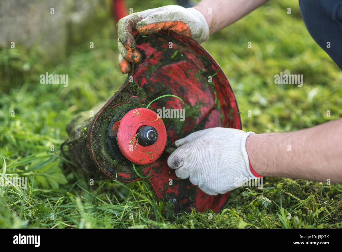 String trimmer cleaning after cutting the grass Stock Photo - Alamy