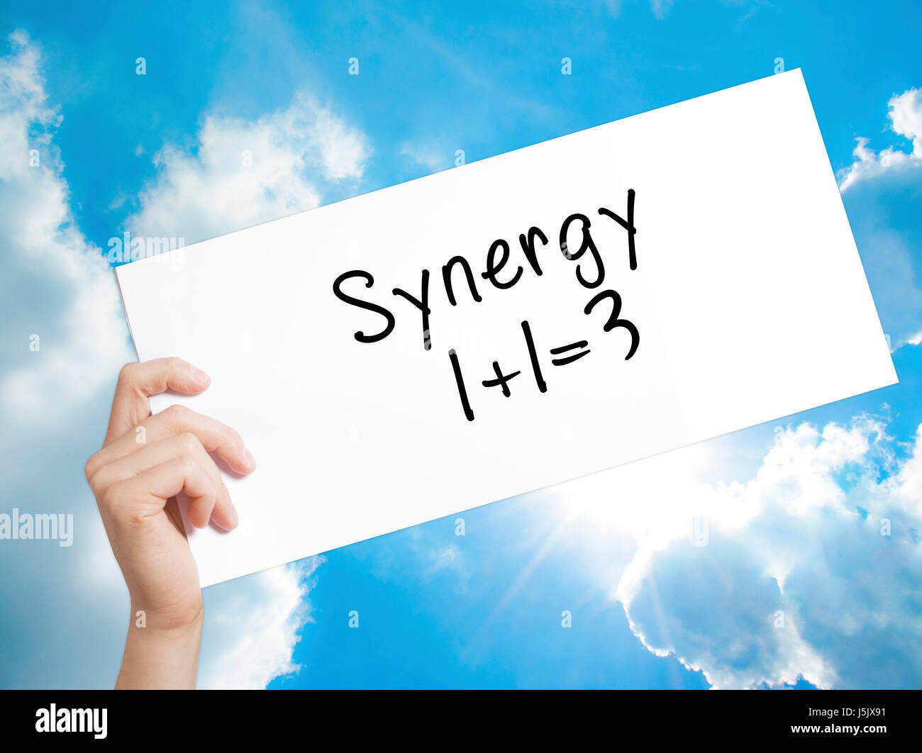 Synergy concept 1+1=3 Sign on white paper. Man Hand Holding Paper with ...