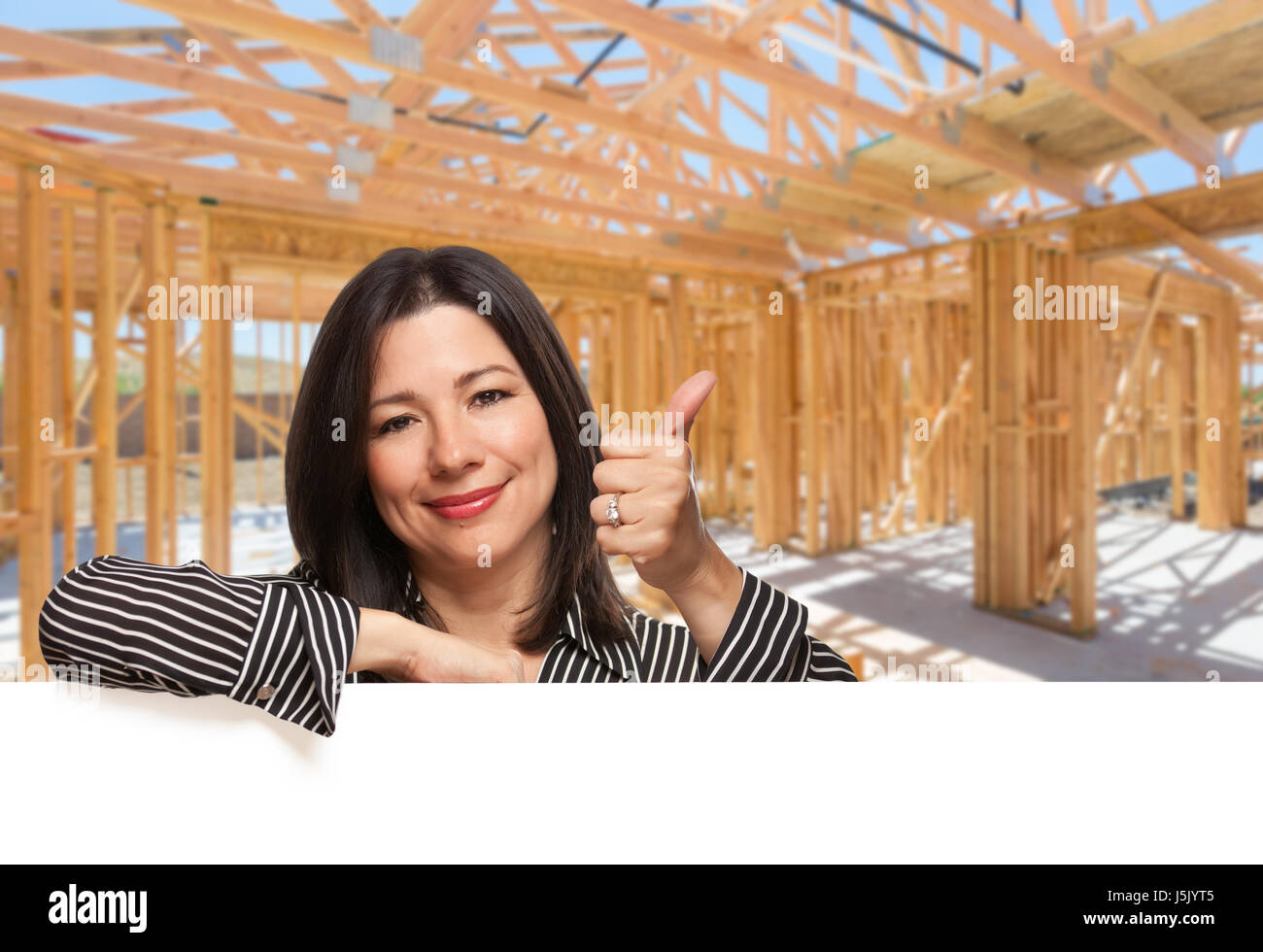Hispanic Woman With Thumbs Up On Site Inside New Home Construction ...