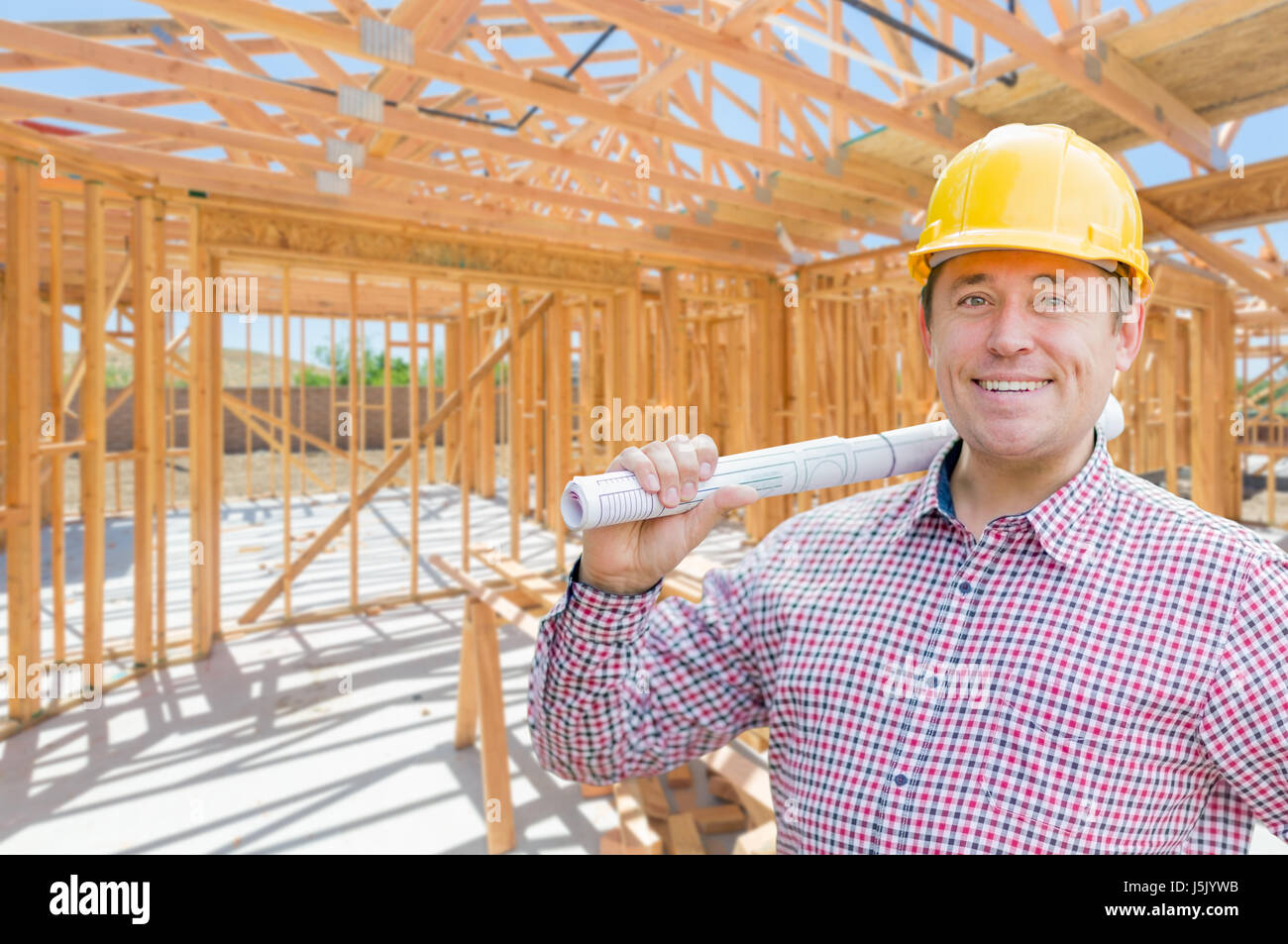 Contractor With Plans On Site Inside New Home Construction Framing ...