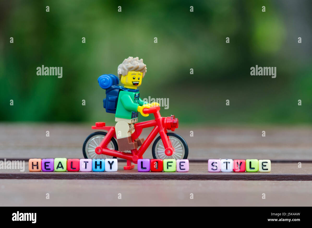 lego hiker riding bicycle with word healthy life style Stock Photo - Alamy