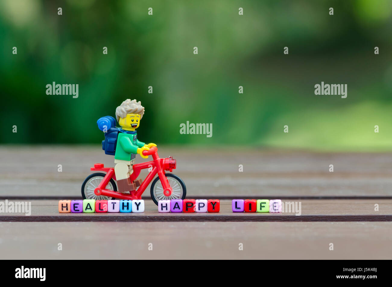 lego hiker riding bicycle with word healthy happy life Stock Photo - Alamy