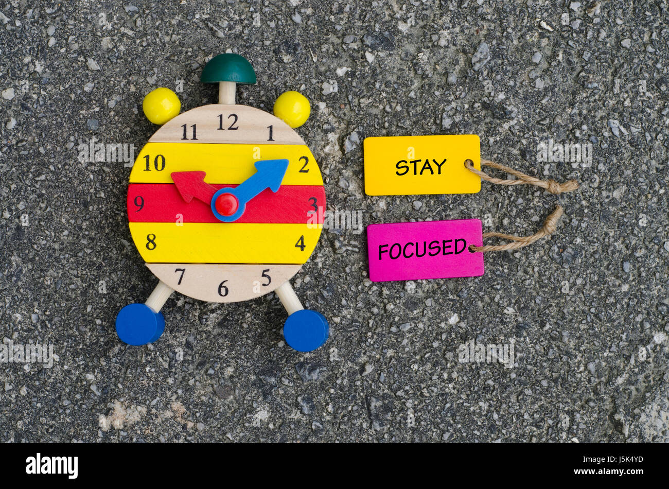 word stay focused written on wooden tag with colorful wooden clock ...
