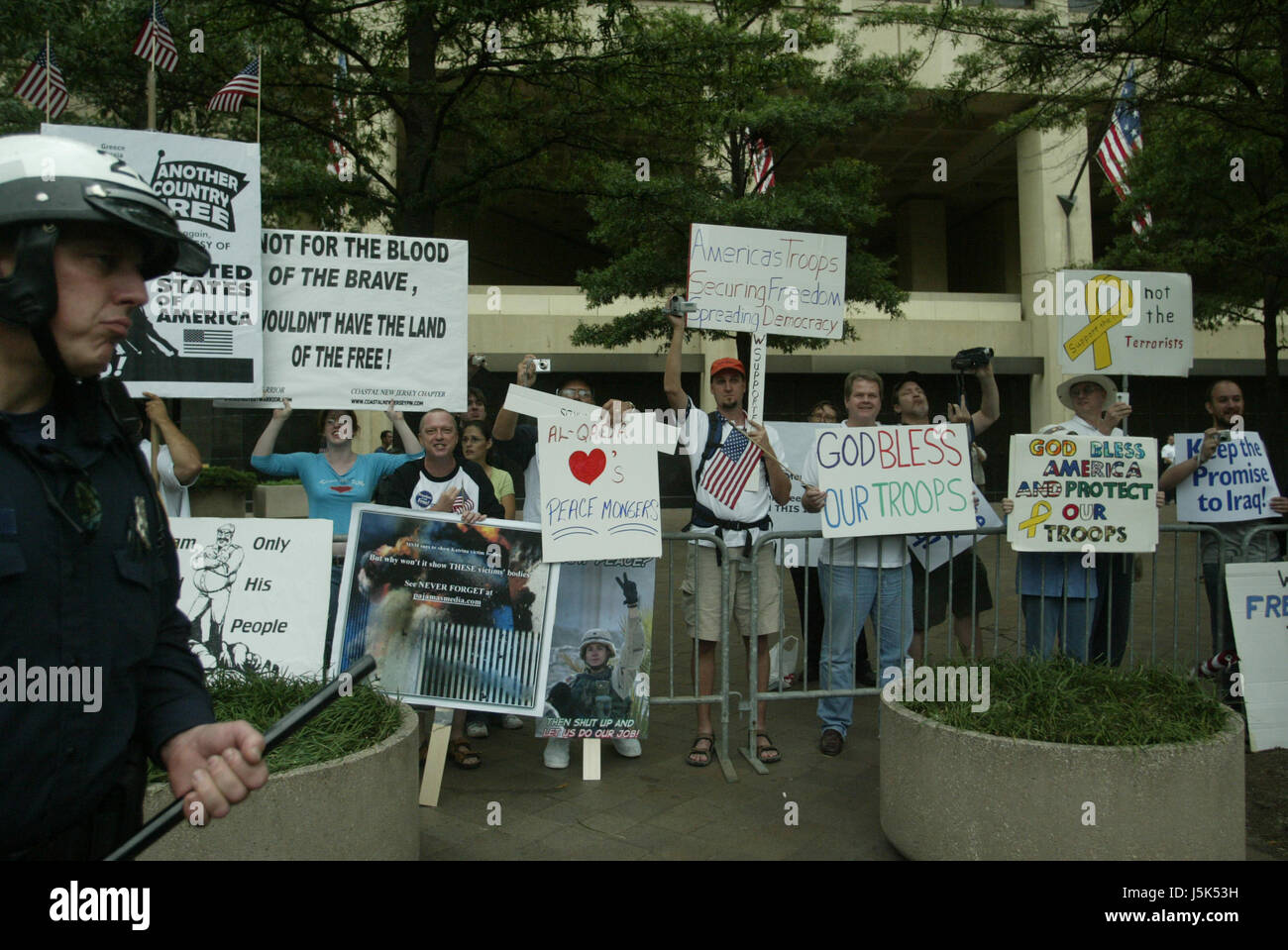 A police officer follows Black Bloc Anarchist while passing anti-war ...