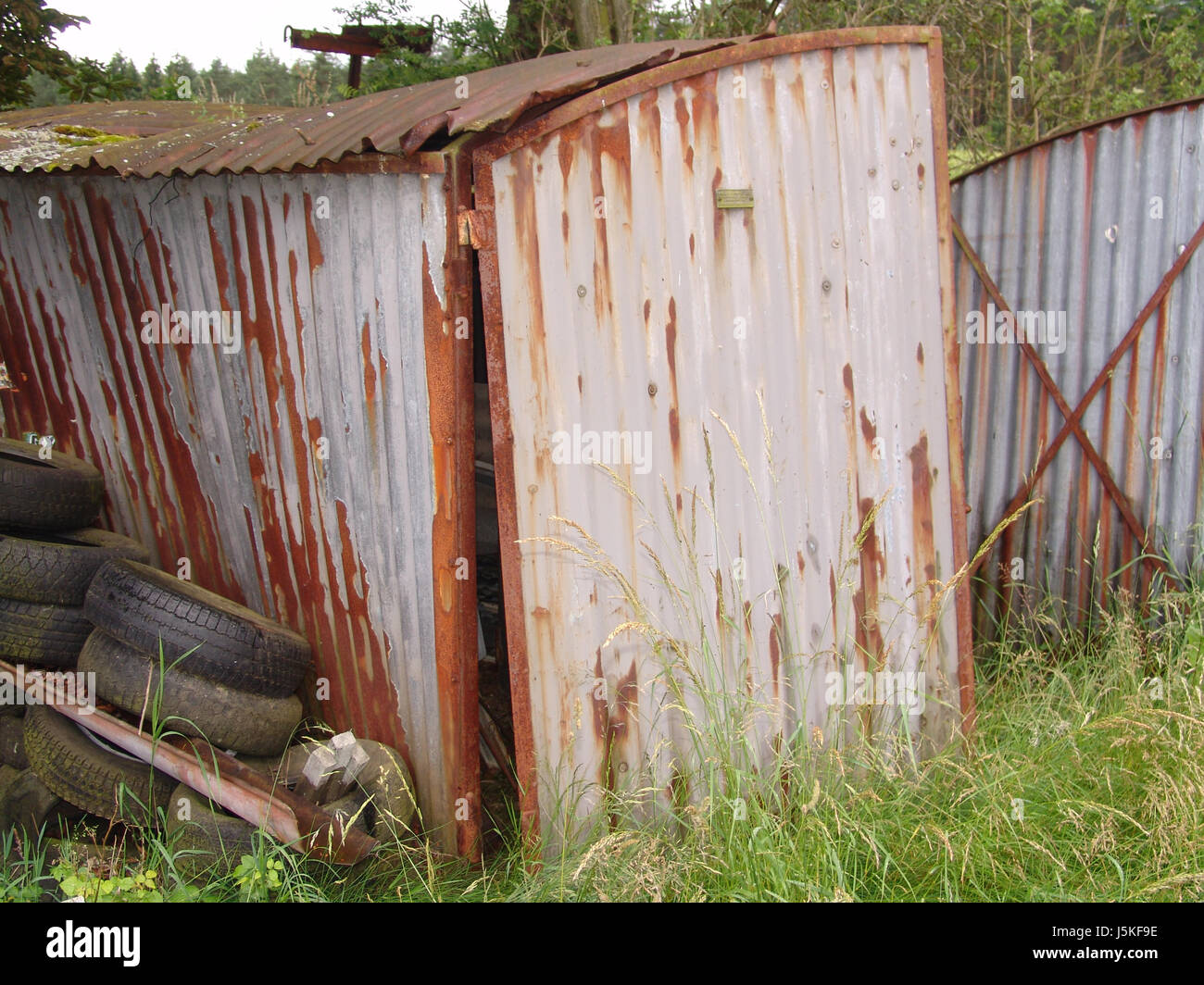 ailing rusty disused garage rust corrugated sheet iron car tire expiry ...