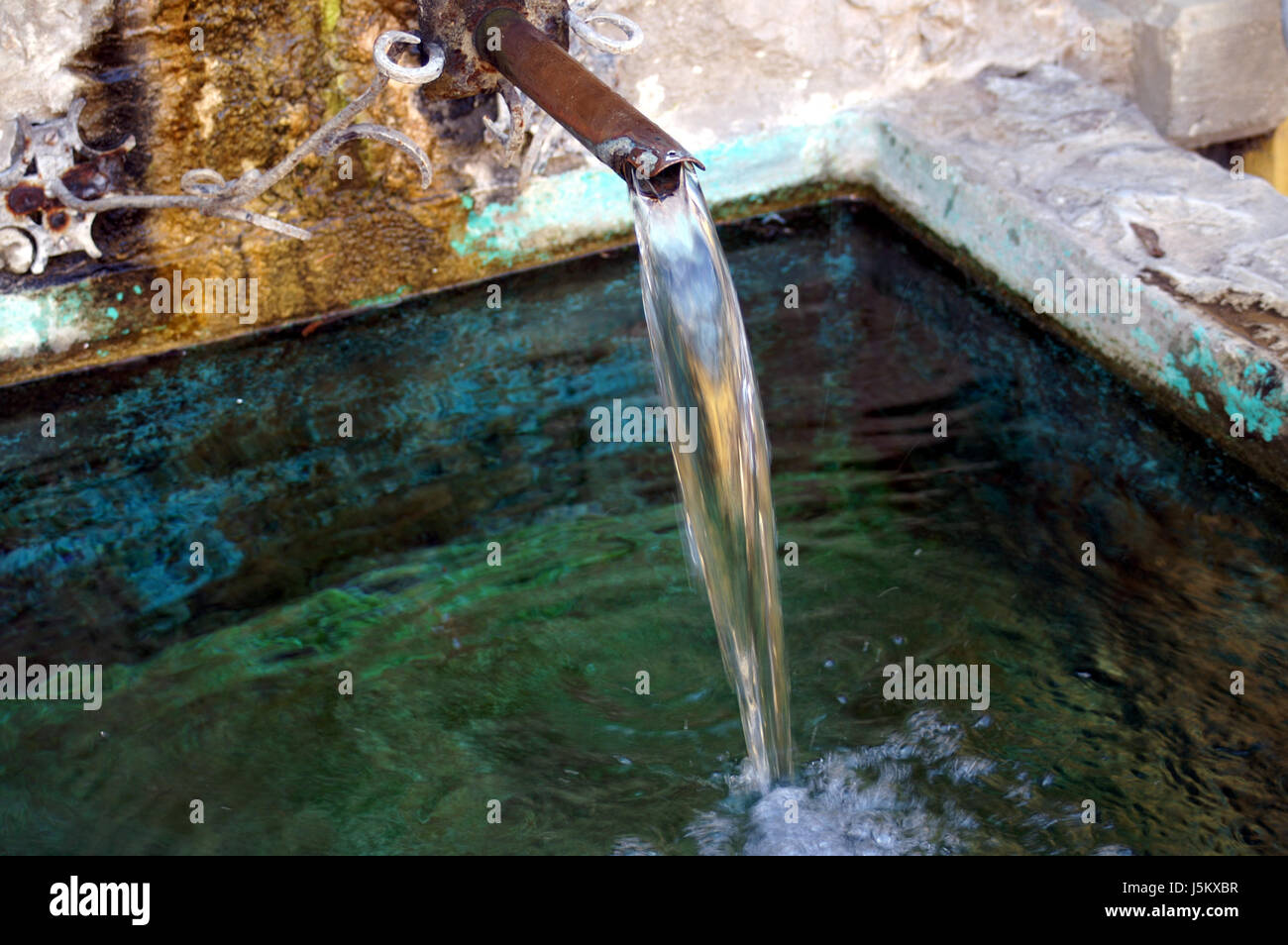 liquid stone wall fountain tap cistern mineral water water ray jet of ...