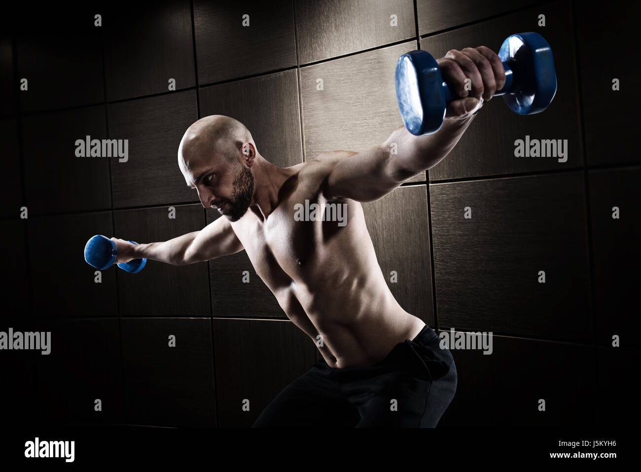 Athletic man training biceps on grunge background Stock Photo - Alamy