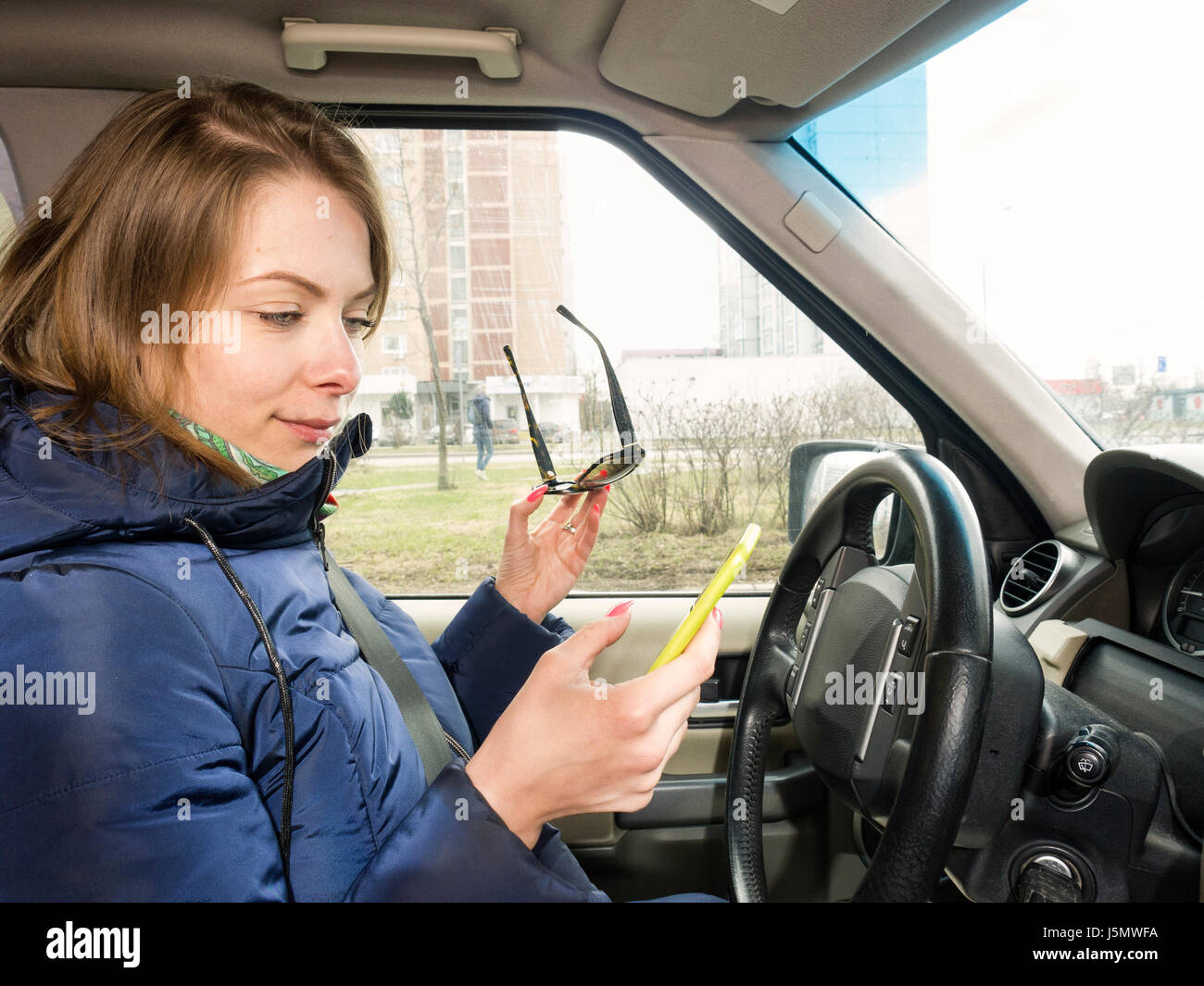 Young female driver busy with a mobile phone Stock Photo - Alamy
