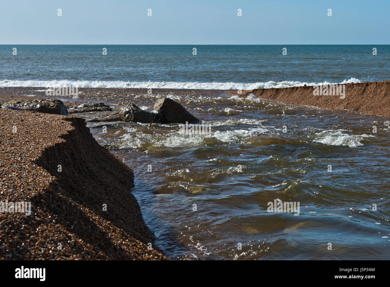 The River Bride crossing the beach and meeting the sea at Burton ...