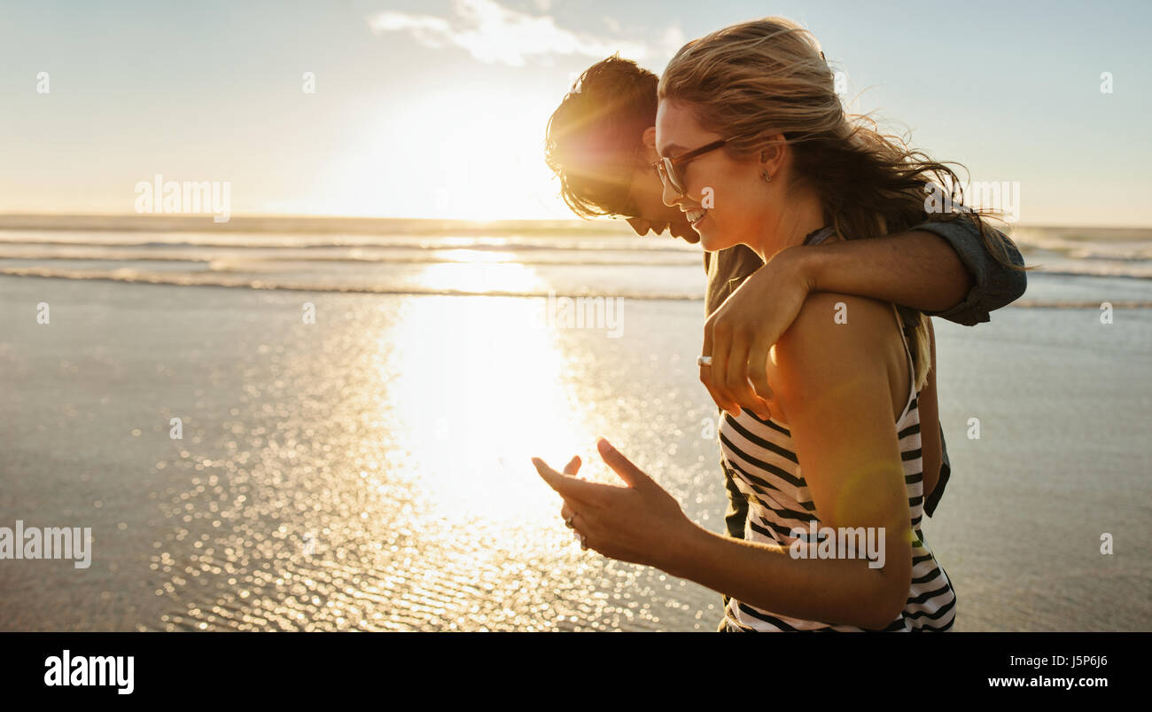 Side view shot of loving young couple enjoying a day on beach ...