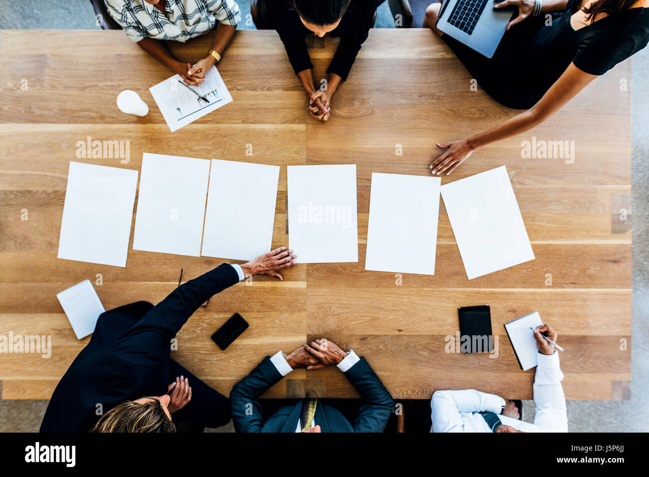 Team of business people sitting around a table and discussing. business ...