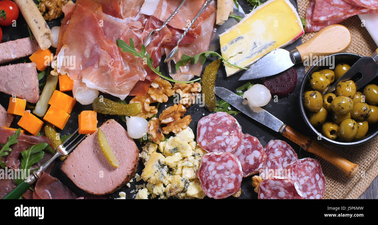Top down view of a platter of cured meat (charcuterie), ham, salami ...