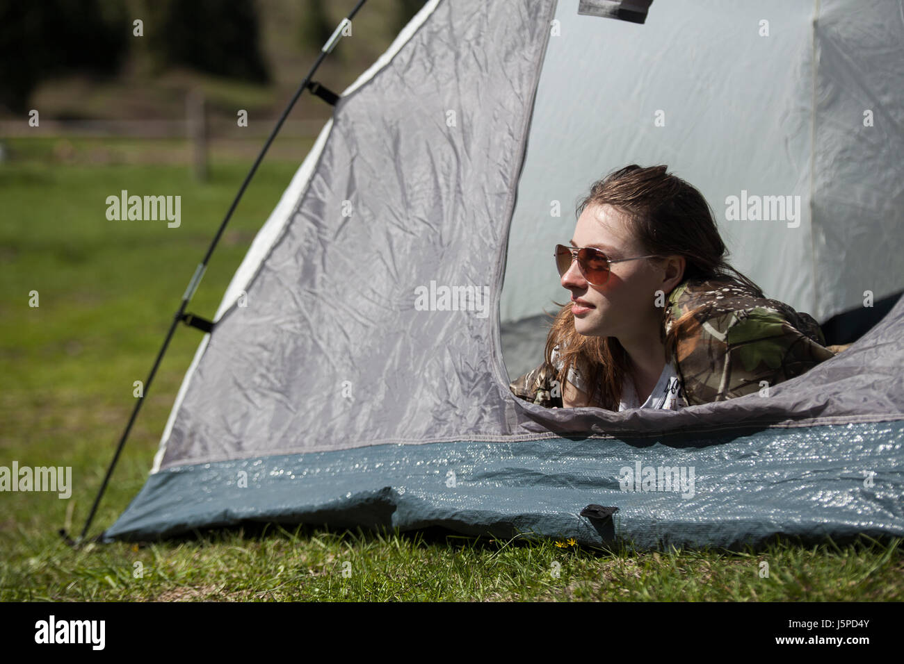 The girl looks out of tent and has a rest Stock Photo - Alamy