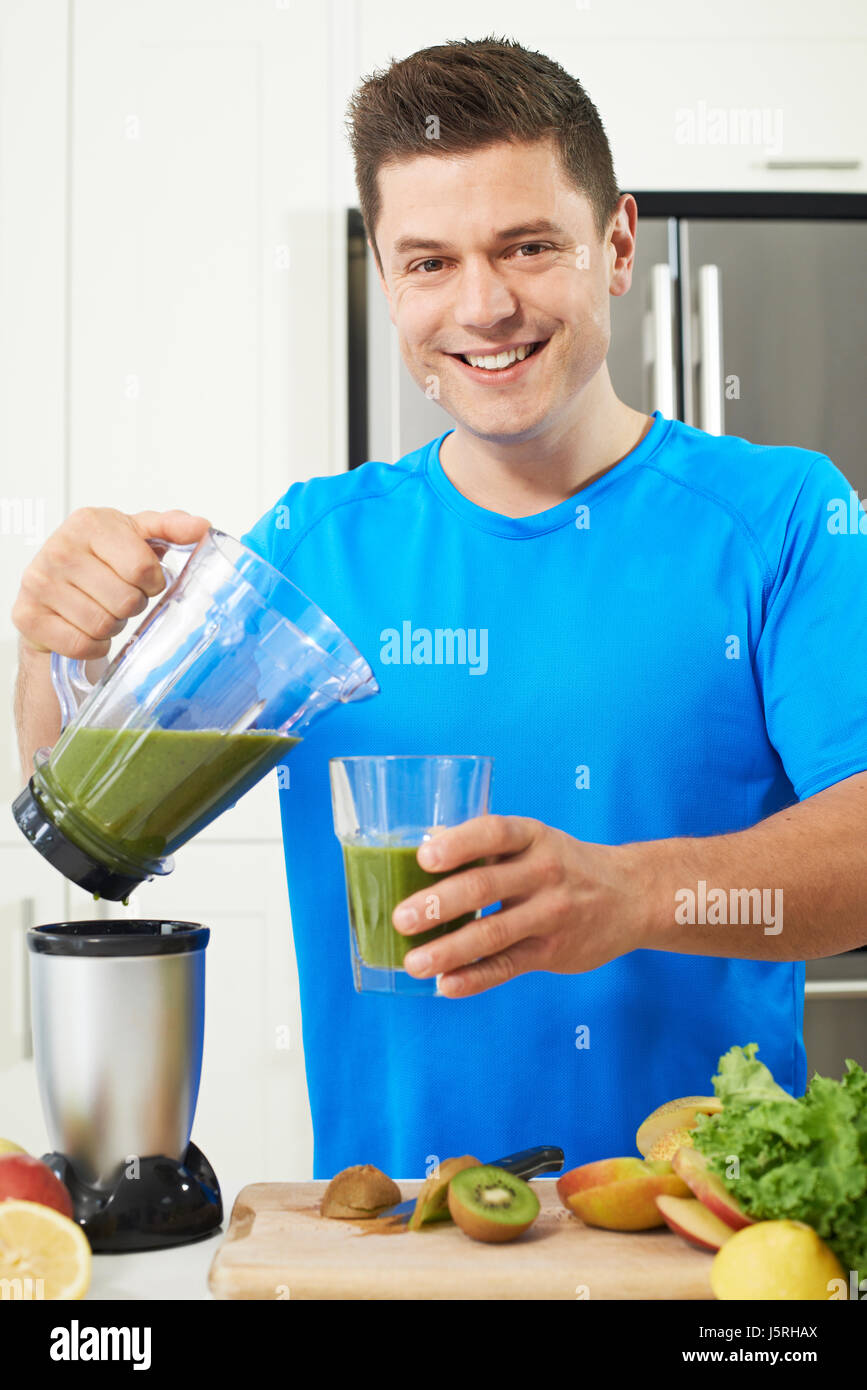 Male Athlete Making Juice Or Smoothie In Kitchen Stock Photo - Alamy