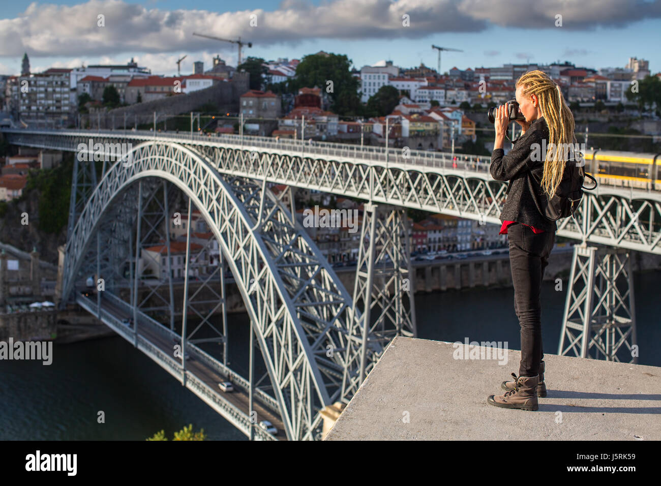 Traveller girl photographer with blonde dreadlocks is takes photo Dom ...