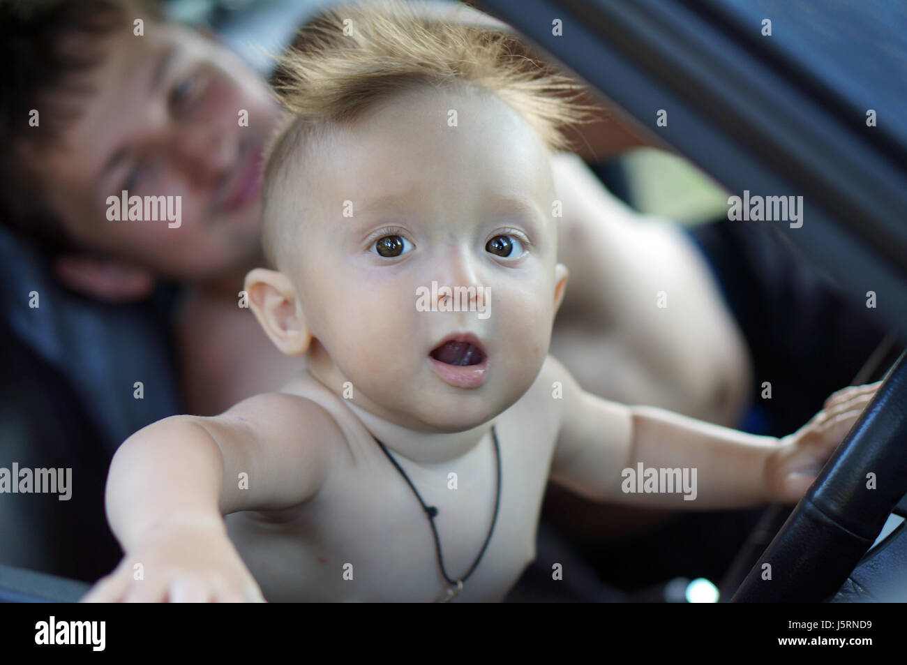 Cute little driver boy sitting in the car and keeps the wheel ...