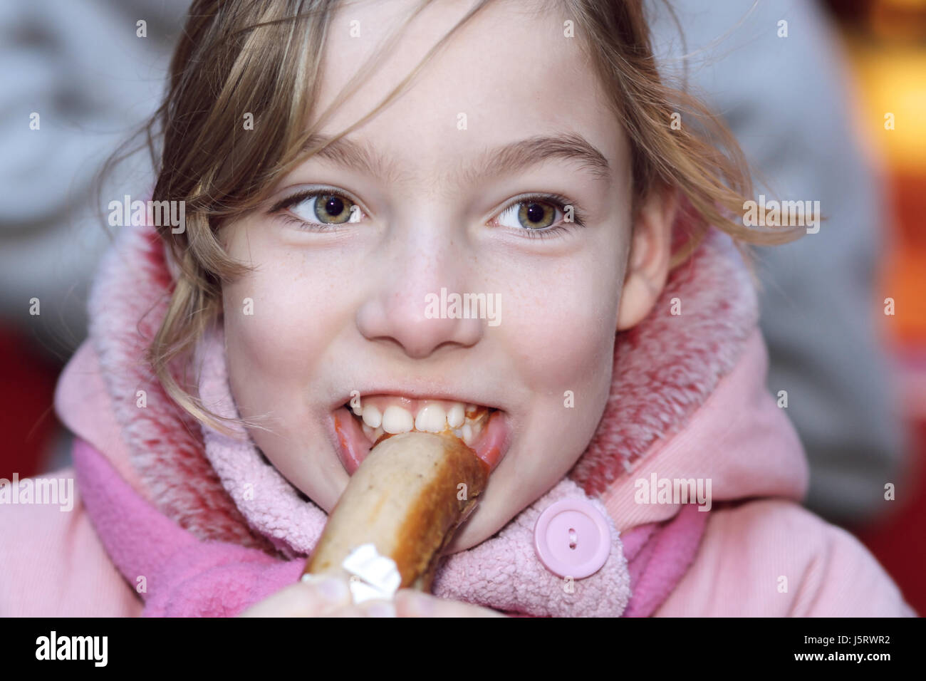 girl nibbling on a sausage Stock Photo - Alamy