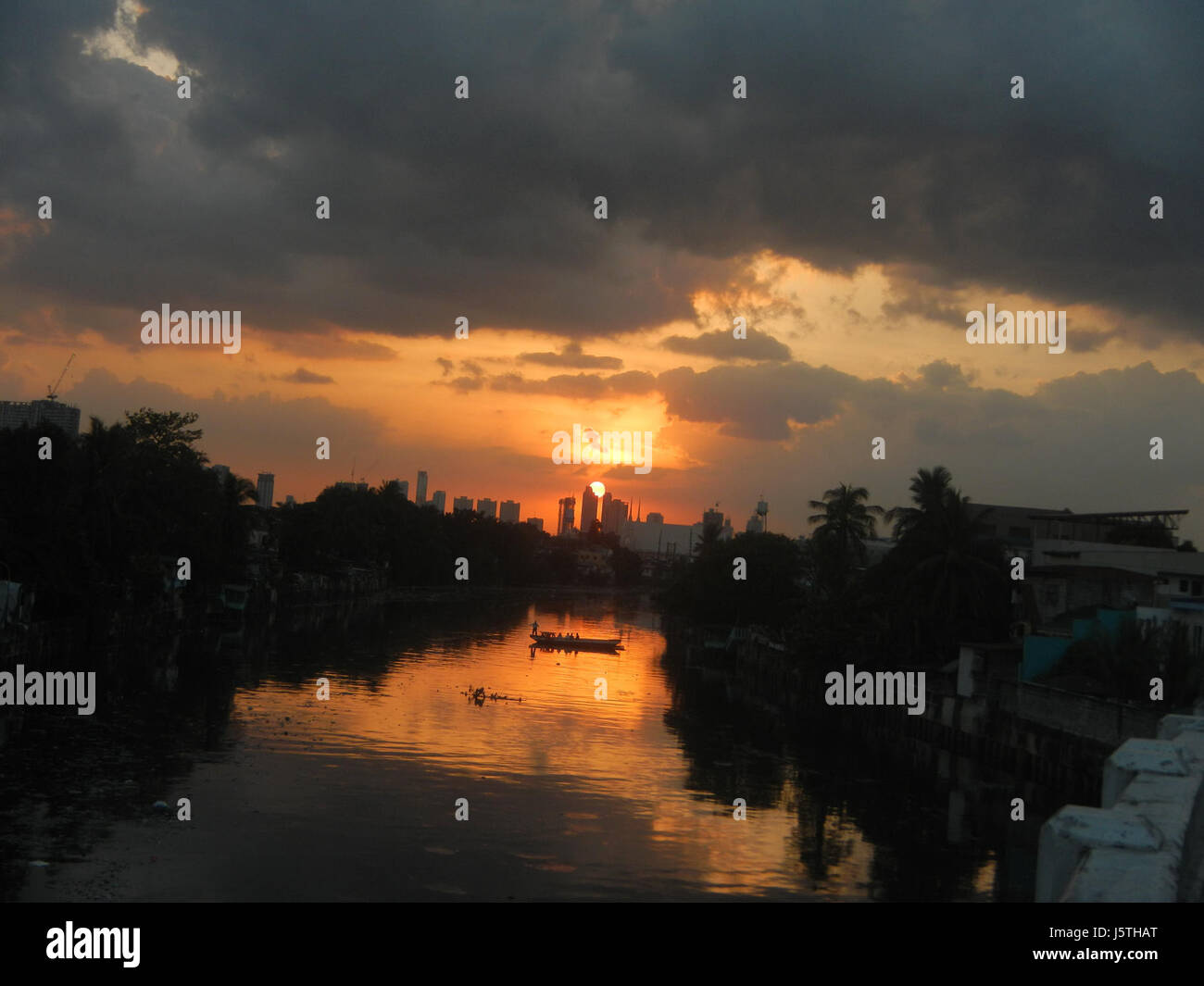A picturesque view of the sunset over the Pasig River, showing ...