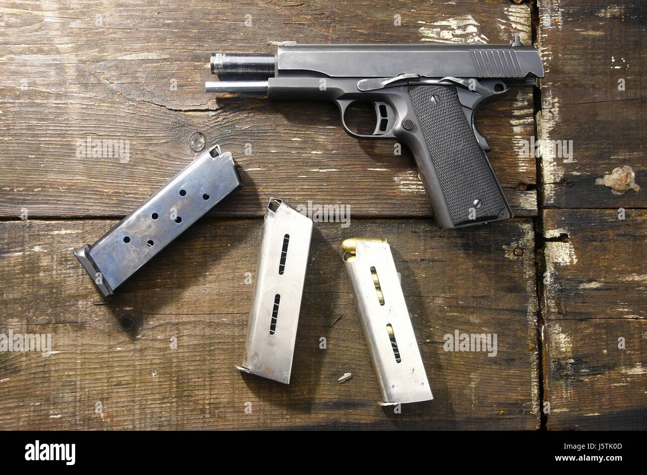 Photo of a gun and bullets on a wooden table Stock Photo - Alamy