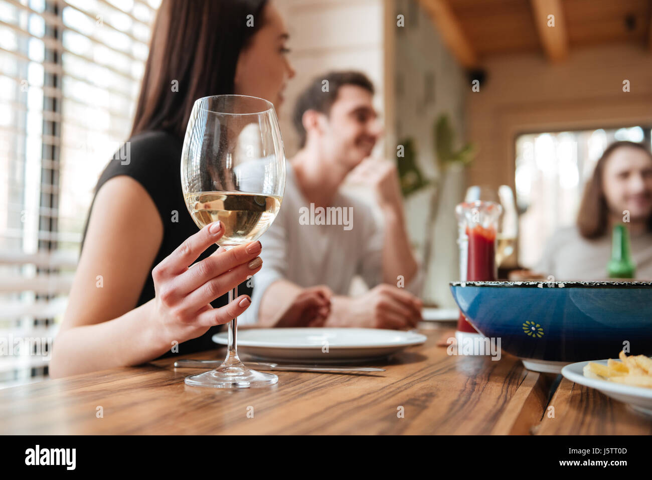 Group of young happy friends having lunch and drinking vine at the ...