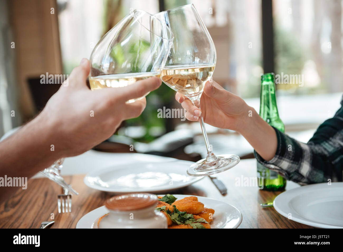 Close up portrait of a female and male hands toasting with glasses of ...