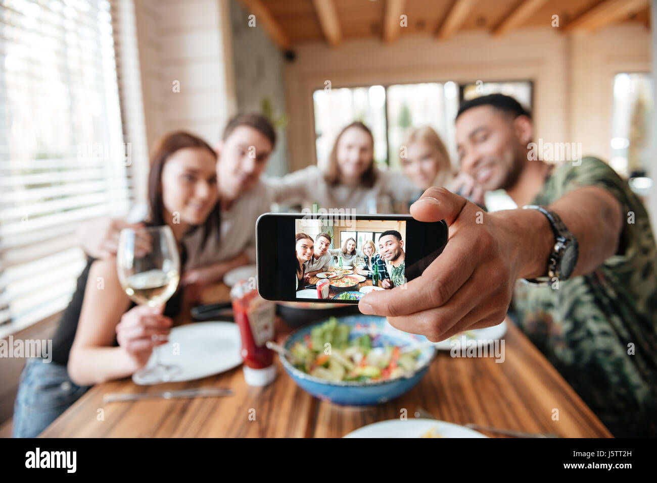 Group Of Friends Having Dinner And Taking Selfie With Smartphone At The