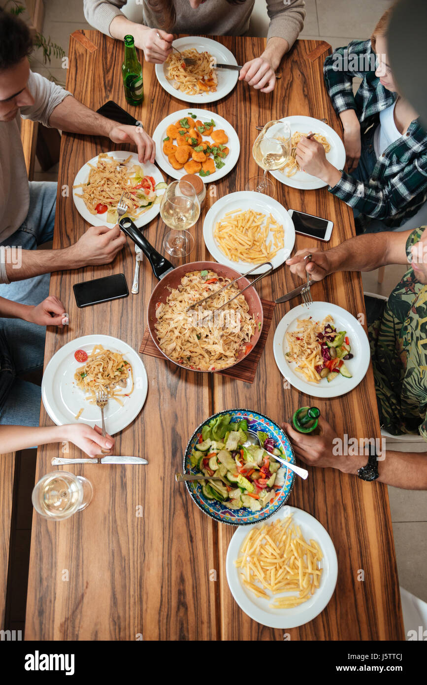 Top view of group of people having dinner together while sitting at the ...