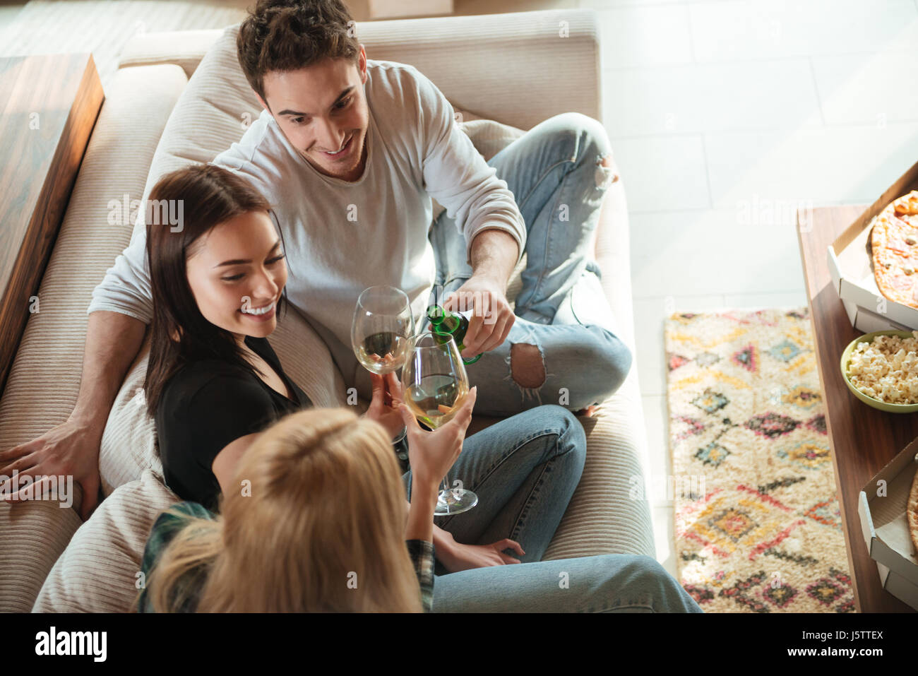 Top view of happy young friends clinking giving toasts and clinking ...