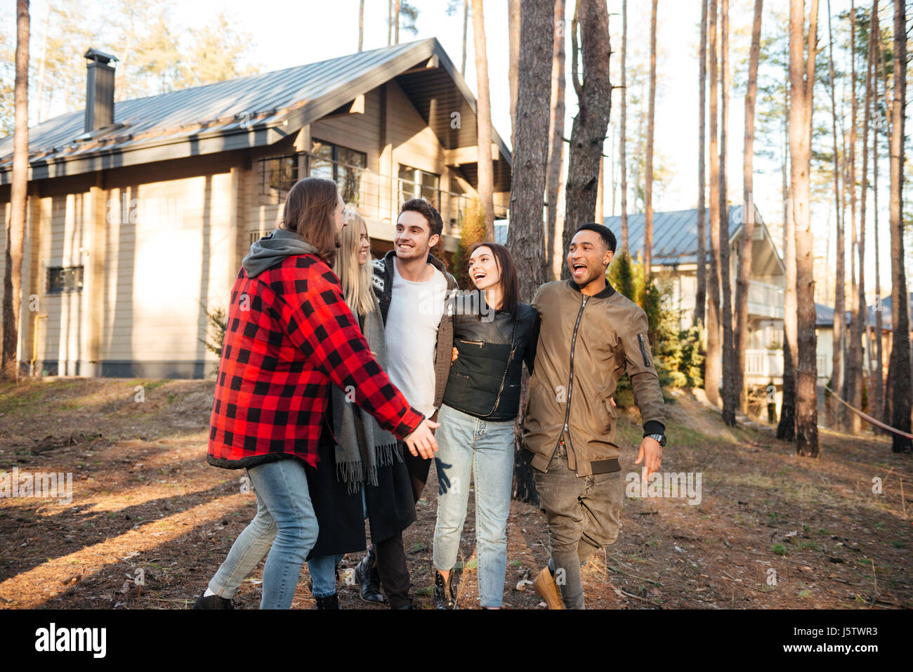 Image of happy group of friends walking outdoors in the forest. Looking ...