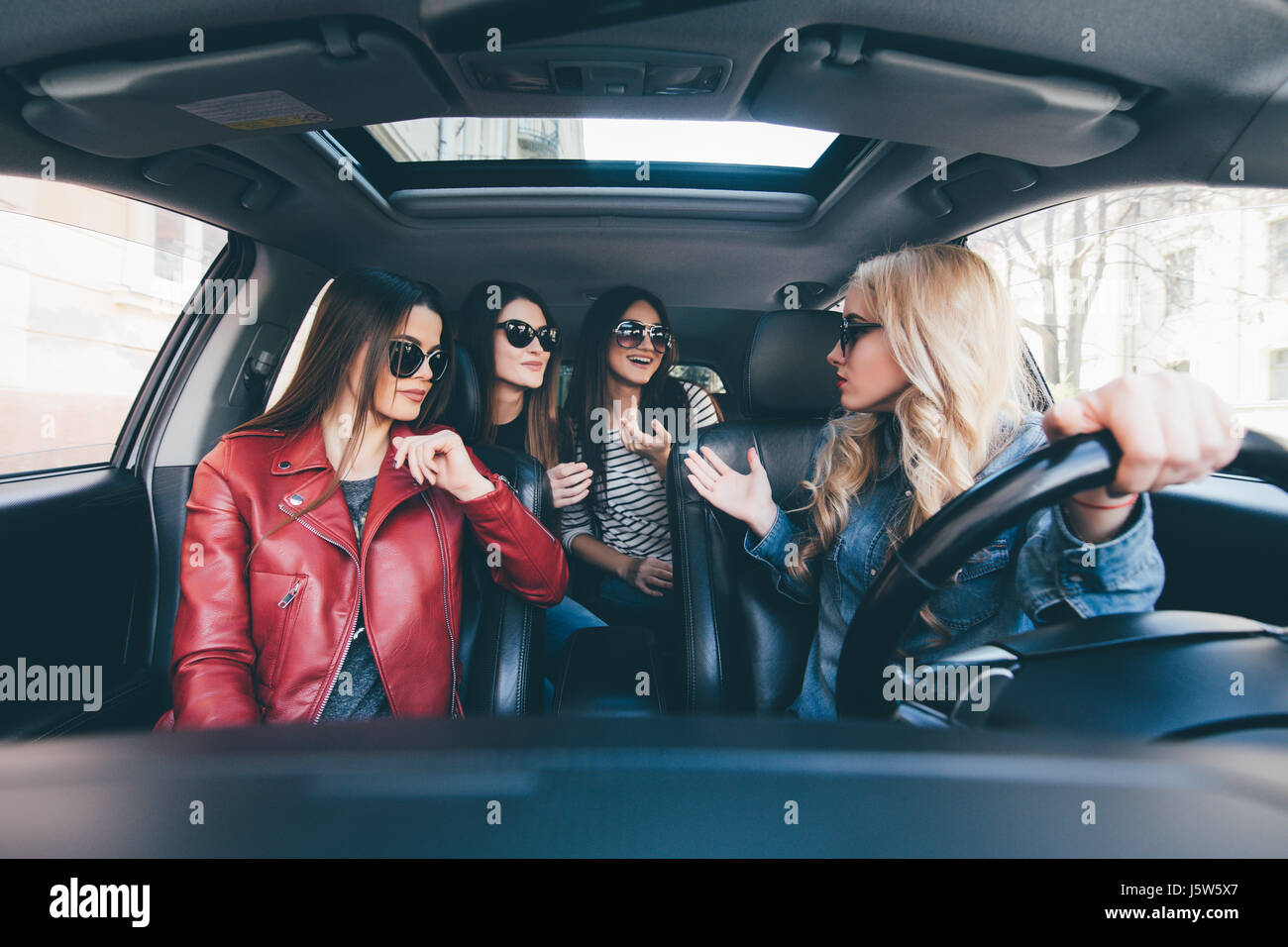 Group of friends having fun on the car. Singing and laughing in the ...