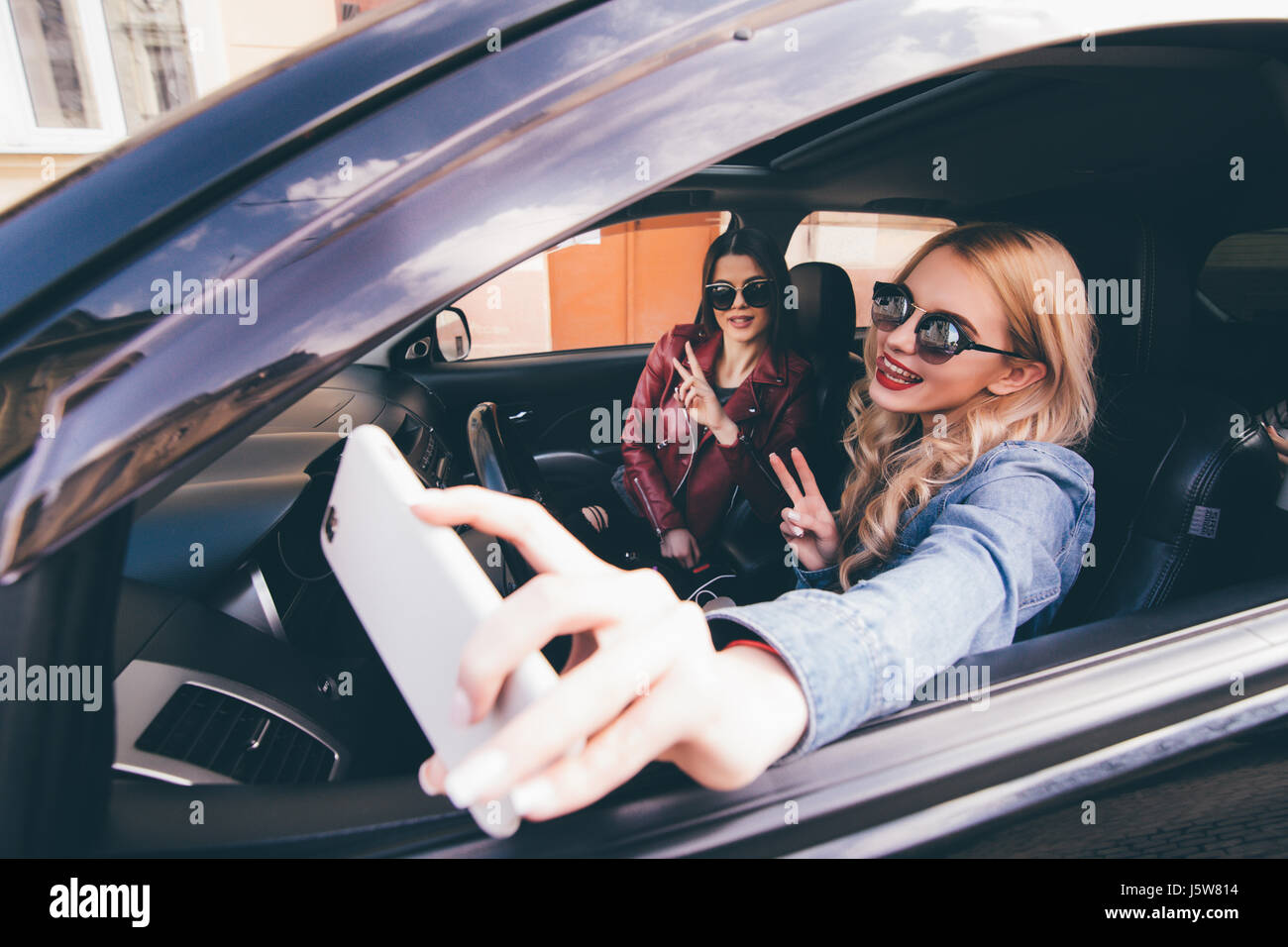 Selfie time side view of four beautiful young cheerful women making ...