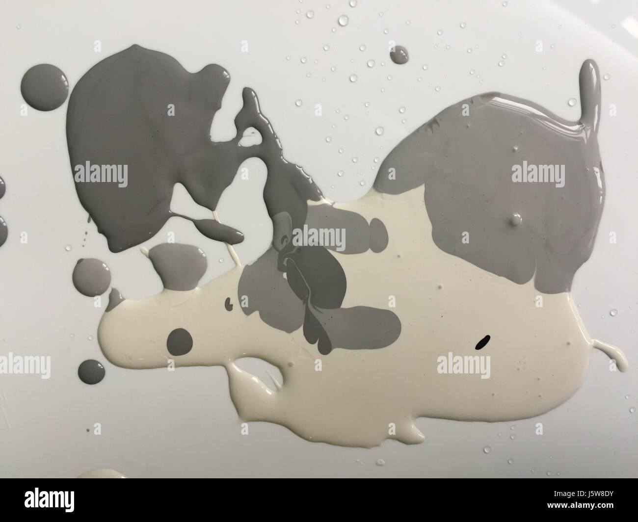 Mixing gray paint test on white plastic background with water drops ...