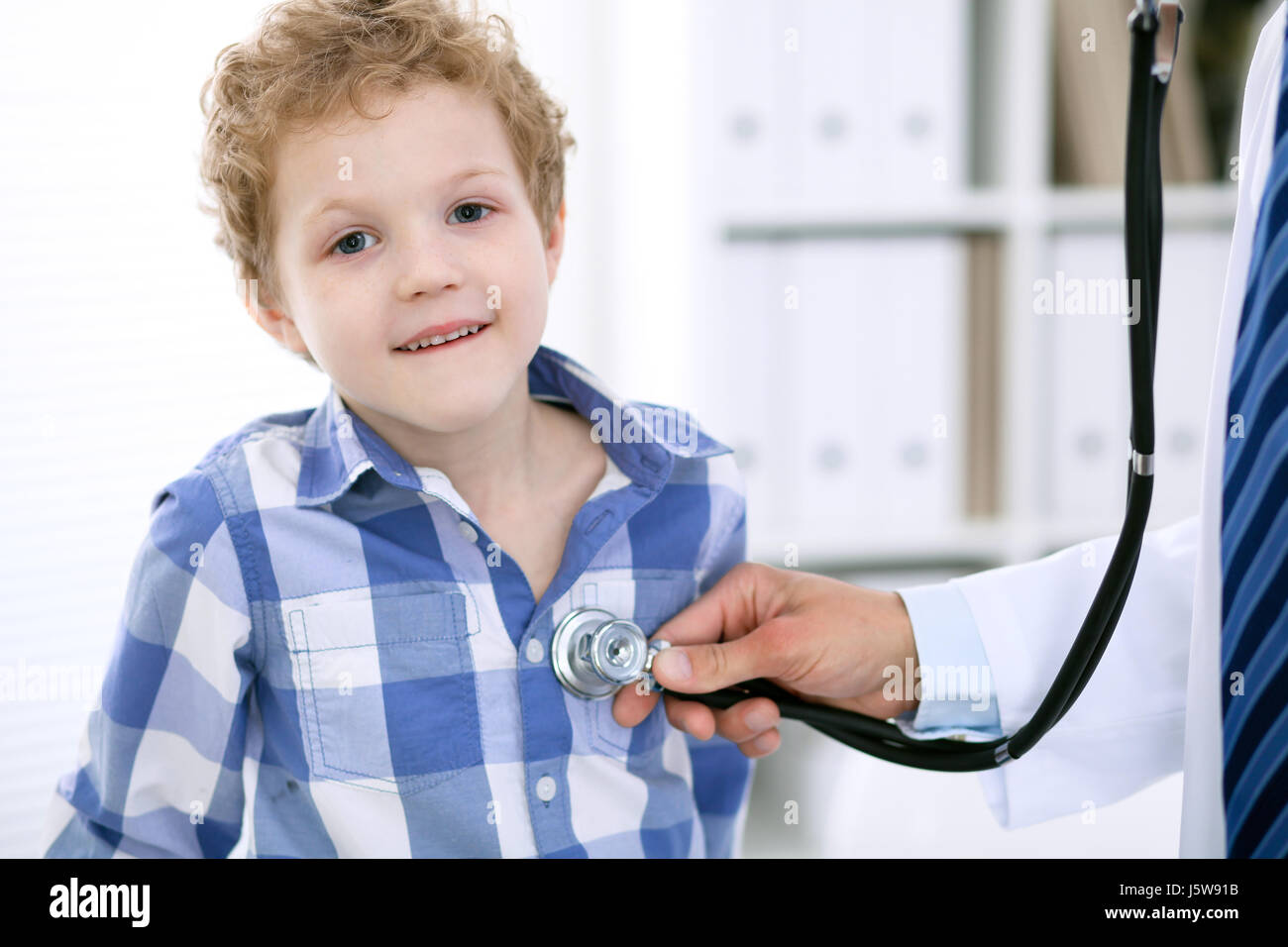 Doctor examining a child patient by stethoscope Stock Photo - Alamy