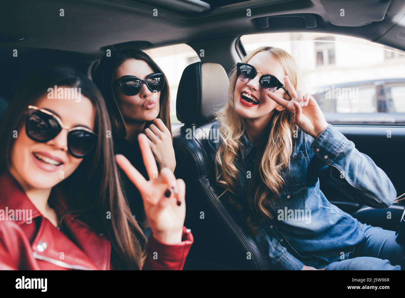 Group of friends having fun on the car. Singing and laughing in the ...