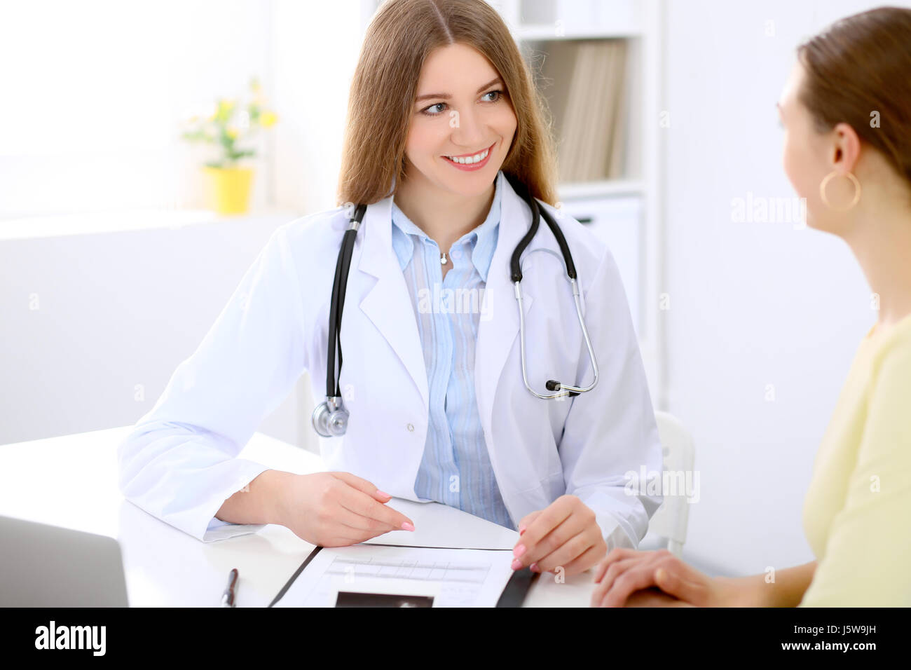 Doctor and patient sitting at the desk near window Stock Photo - Alamy