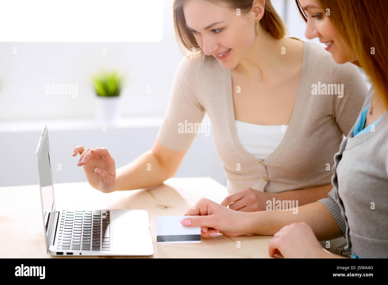 Two friends or sisters talking taking a conversation at the table with ...