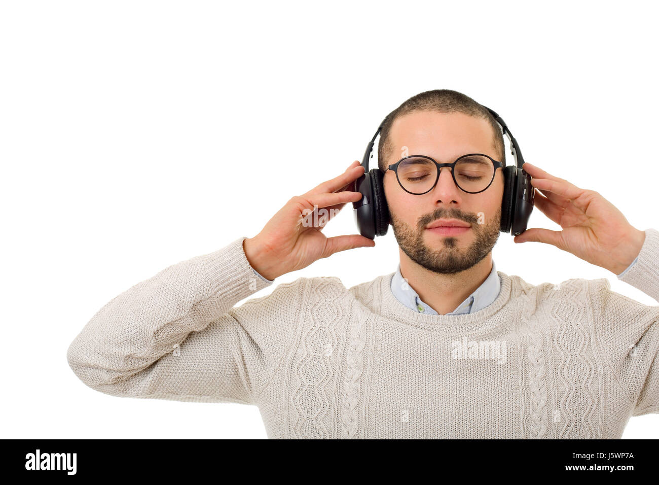 Casual young man listening music with headphones, isolated on white ...