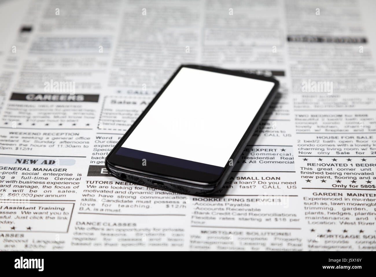 Fake newspaper and smartphone with blank screen. business communication ...