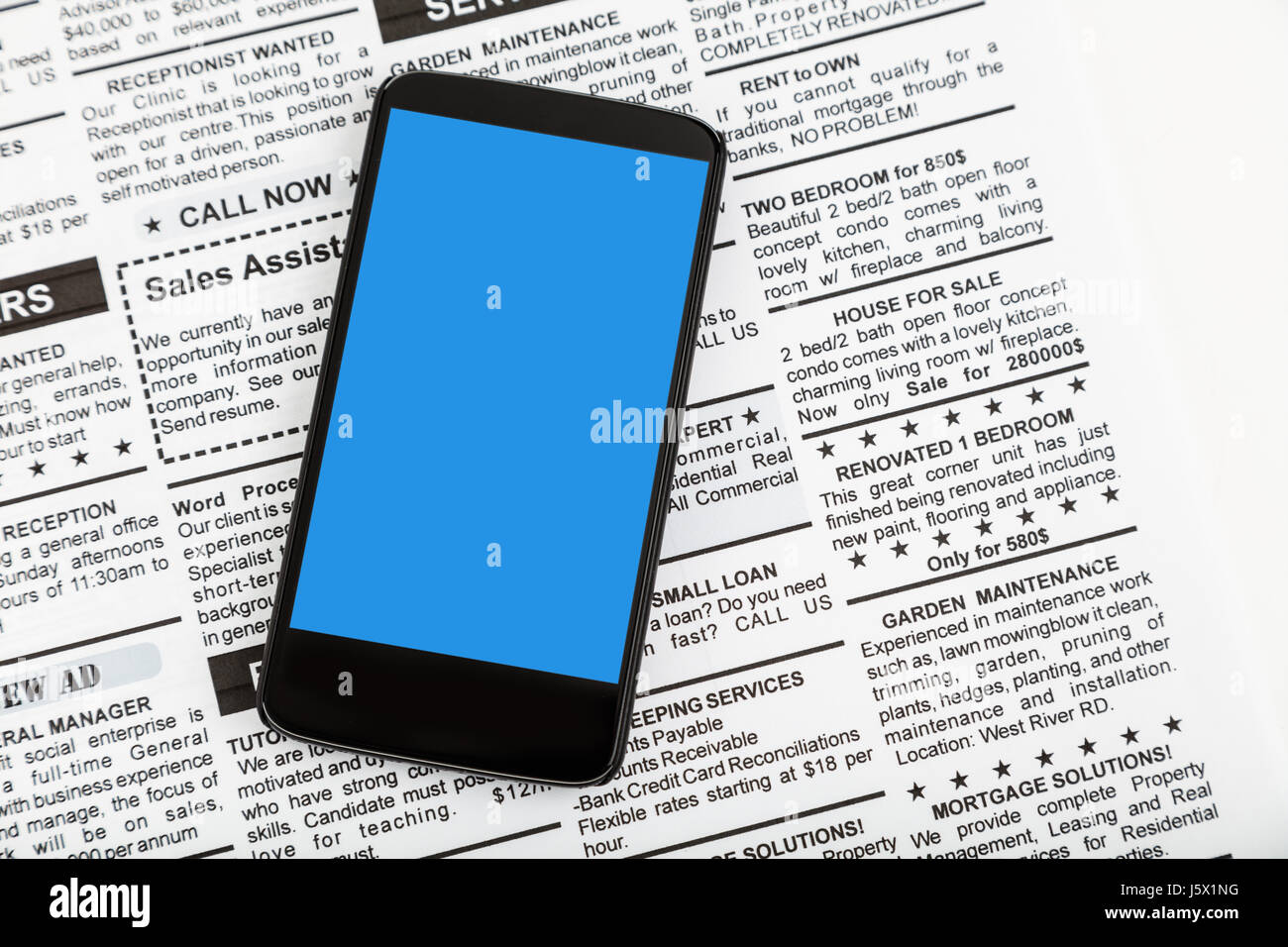 Fake newspaper and smartphone with blank screen. business communication ...