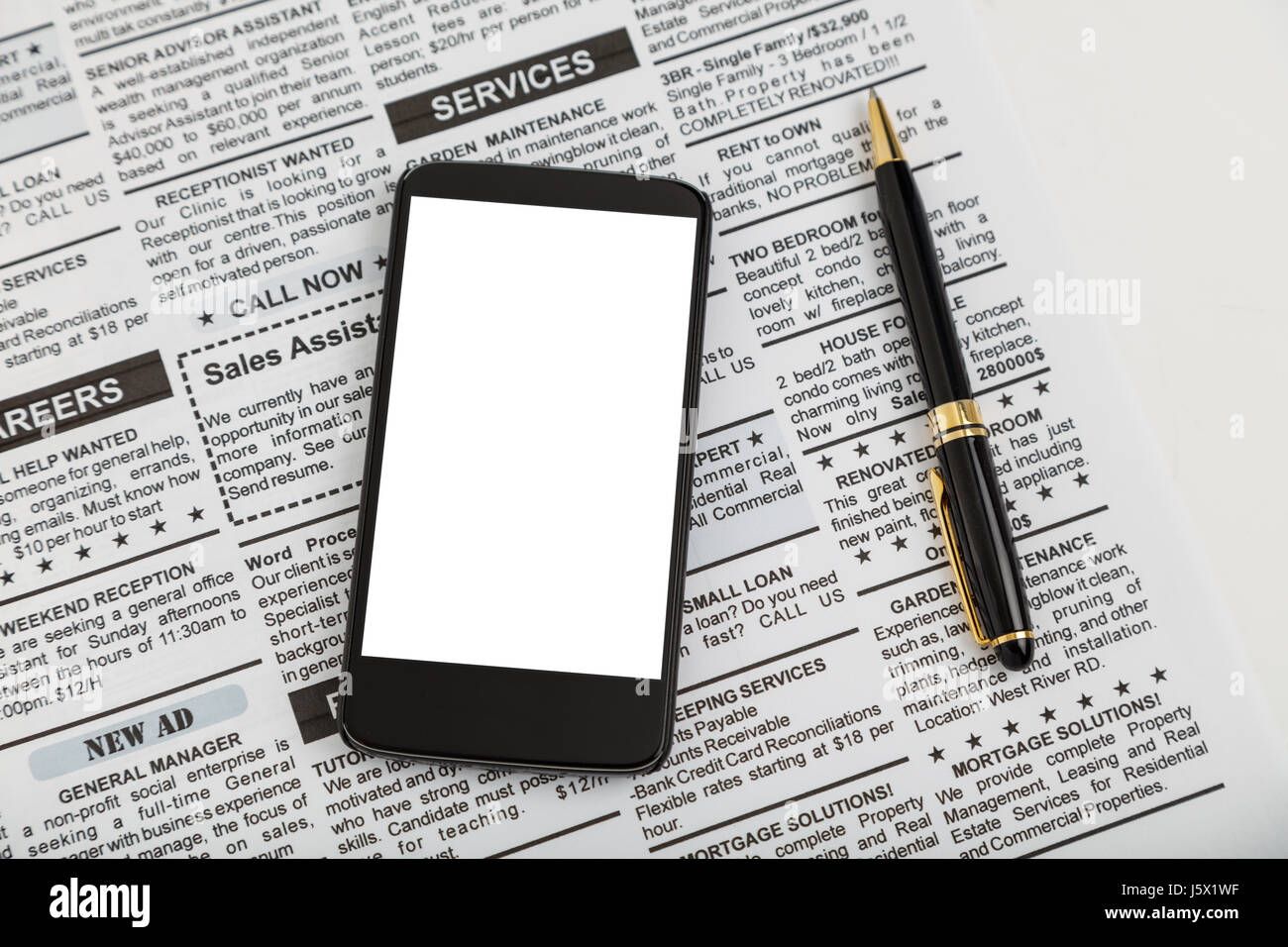 Fake newspaper and smartphone with blank screen. business communication ...