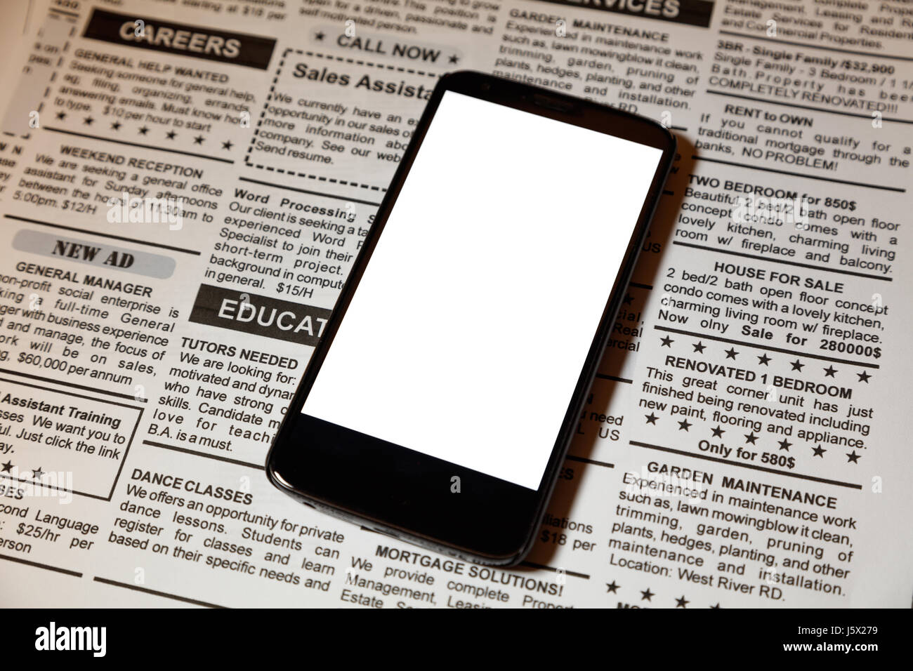 Fake newspaper and smartphone with blank screen. business communication ...