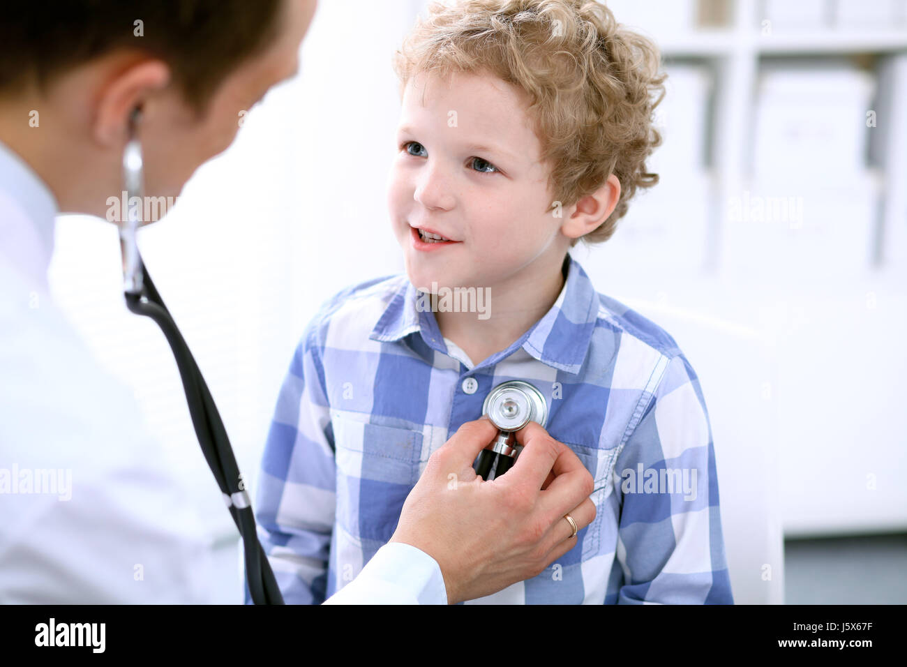 Doctor examining a child patient by stethoscope Stock Photo - Alamy