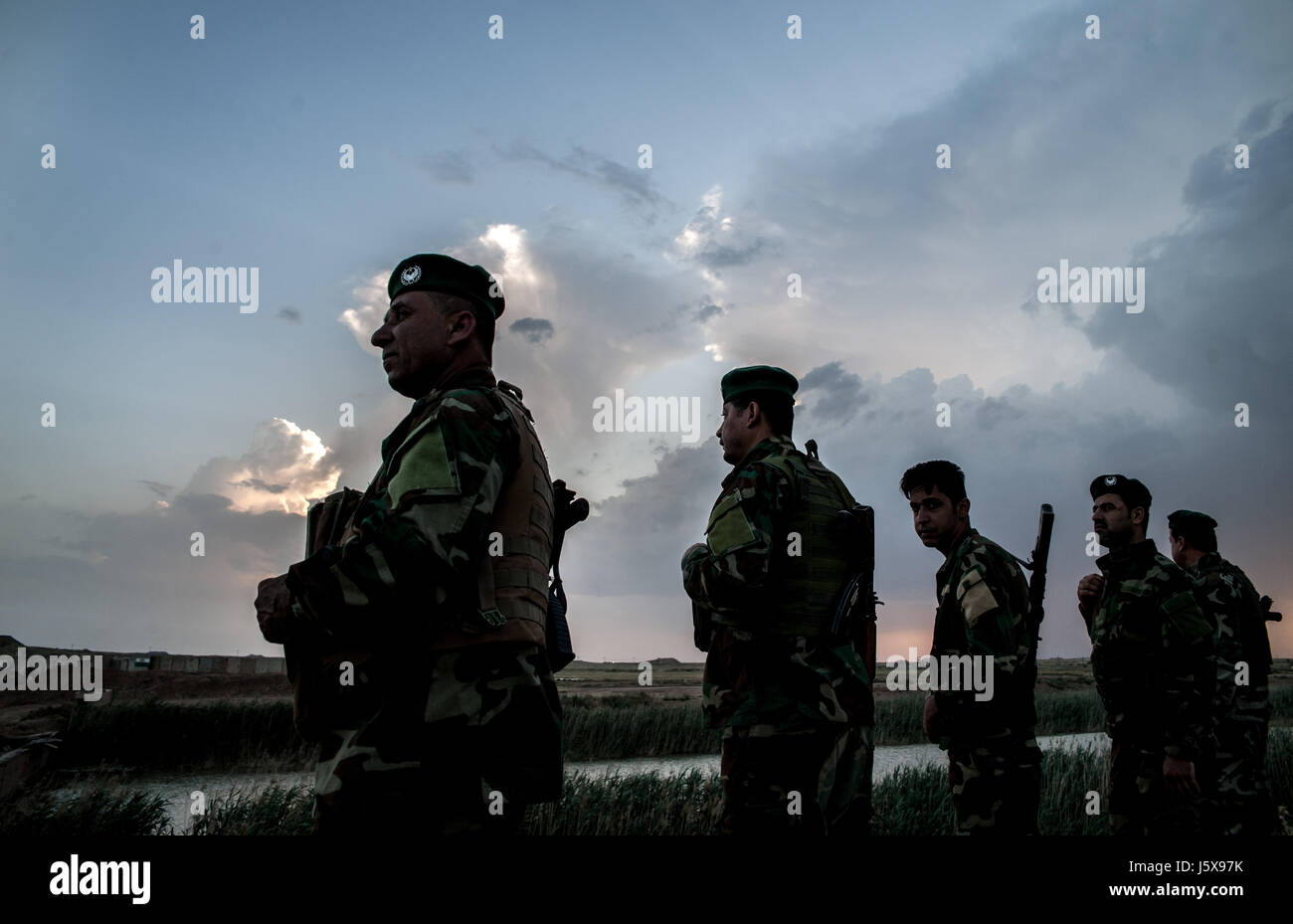 Kurdish Peshmerga forces stand guard at a checkpoint near the frontline ...
